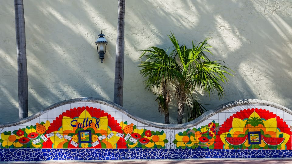 Parede colorida com azulejos, uma palmeira e um poste de luz.