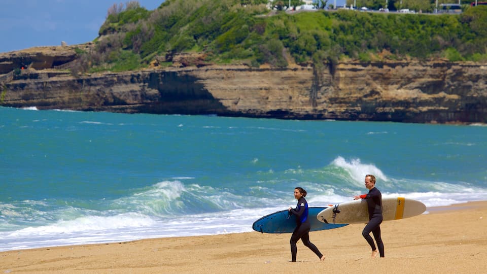 Grand Beach featuring rocky coastline, surfing and a sandy beach