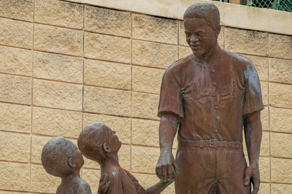 Estátua em bronze de um homem e duas crianças.