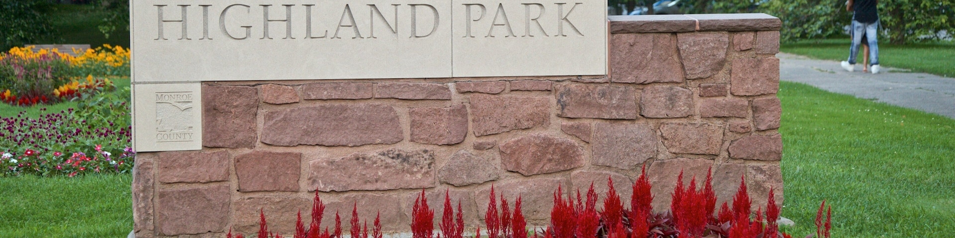 Highland Park featuring signage, a park and wildflowers