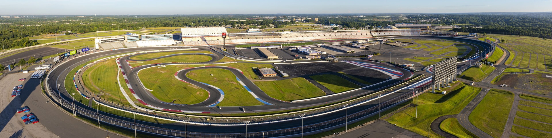 Uma grande pista de corrida oval, com várias faixas e uma arquibancada ao fundo.