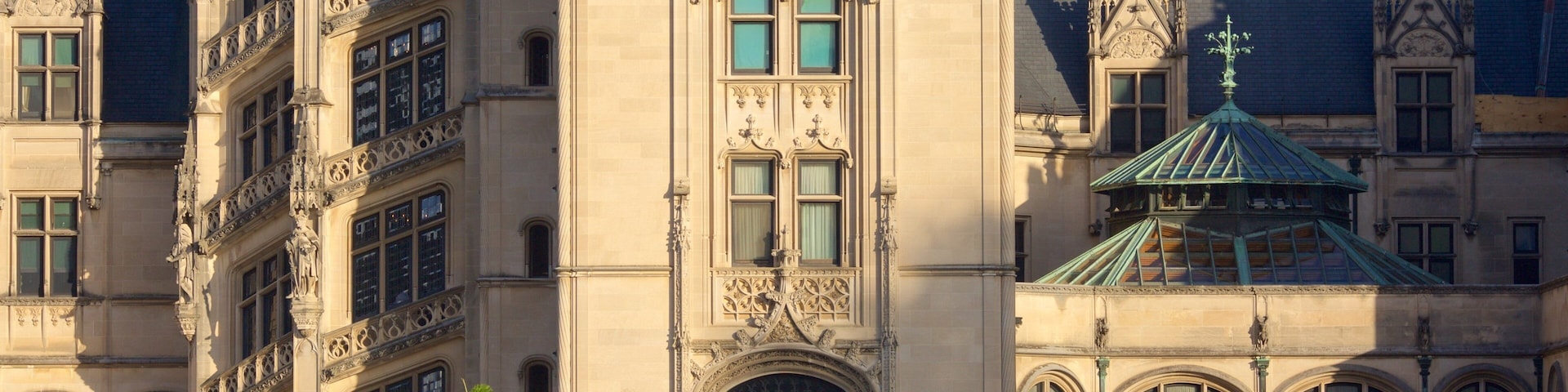 Um edifício imponente com arquitetura elaborada, grandes janelas e uma entrada destacada.