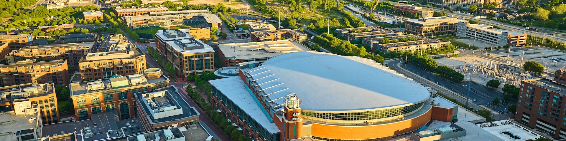 Um estádio grande cercado por edifícios urbanos e um céu limpo.