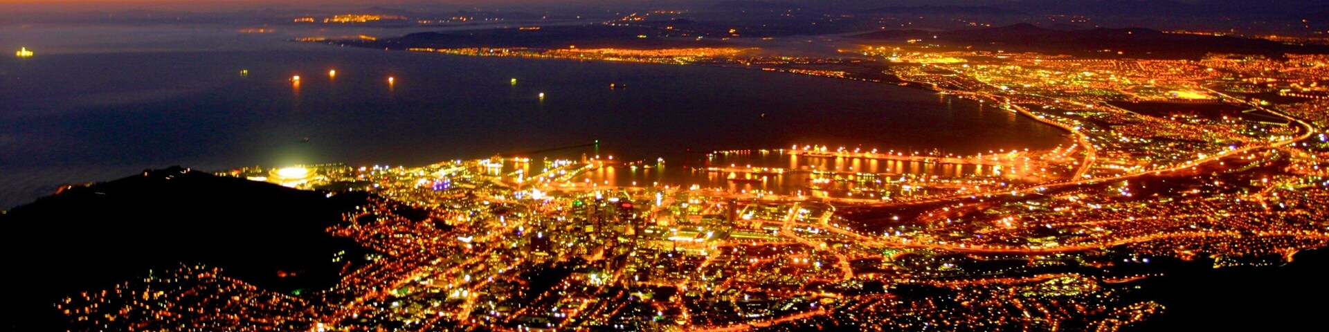 Table Mountain which includes a city, general coastal views and night scenes