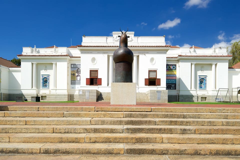 Um edifício com uma grande estátua de bronze em frente.