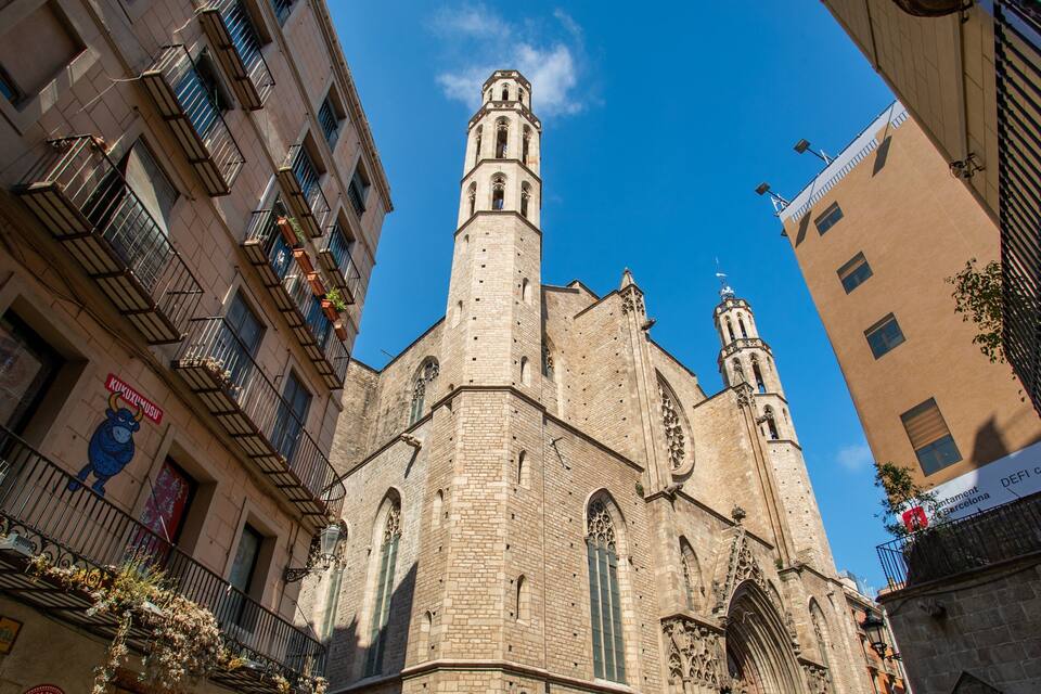 Uma catedral histórica com uma alta torre de sino e detalhes arquitetônicos elaborados.