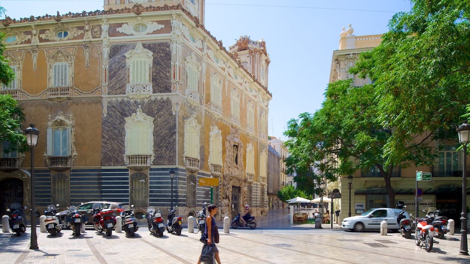 Um edifício histórico com arquitetura ornamentada, motocicletas estacionadas e uma faixa de pedestres.