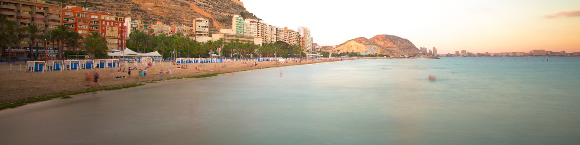 Postiguet Beach which includes a sunset, landscape views and a coastal town