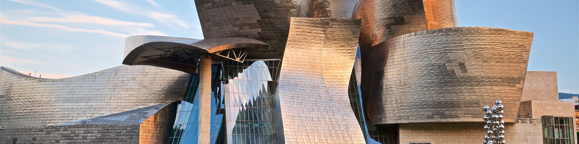 Museu Guggenheim de Bilbao que inclui um pôr do sol, arquitetura moderna e um rio ou córrego