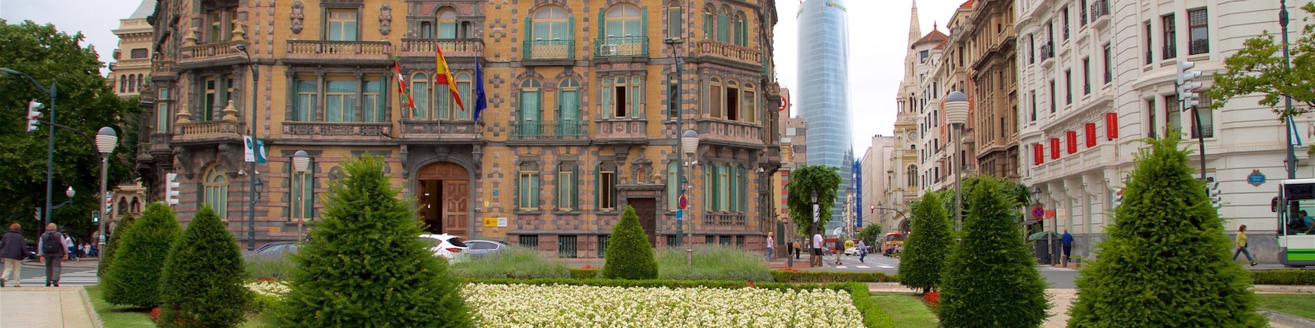Plaza Moyua which includes flowers, a skyscraper and heritage architecture