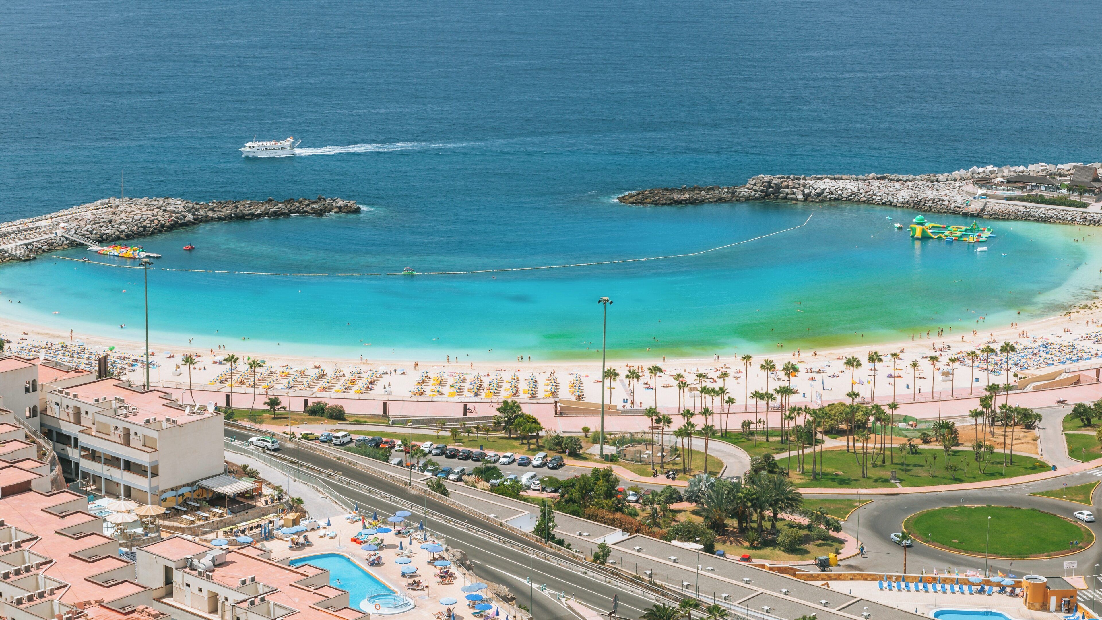 Beautiful Amadores Beach in Las Palmas de Gran Canaria showcases clear waters and sandy shores on a sunny day in the Canary Islands