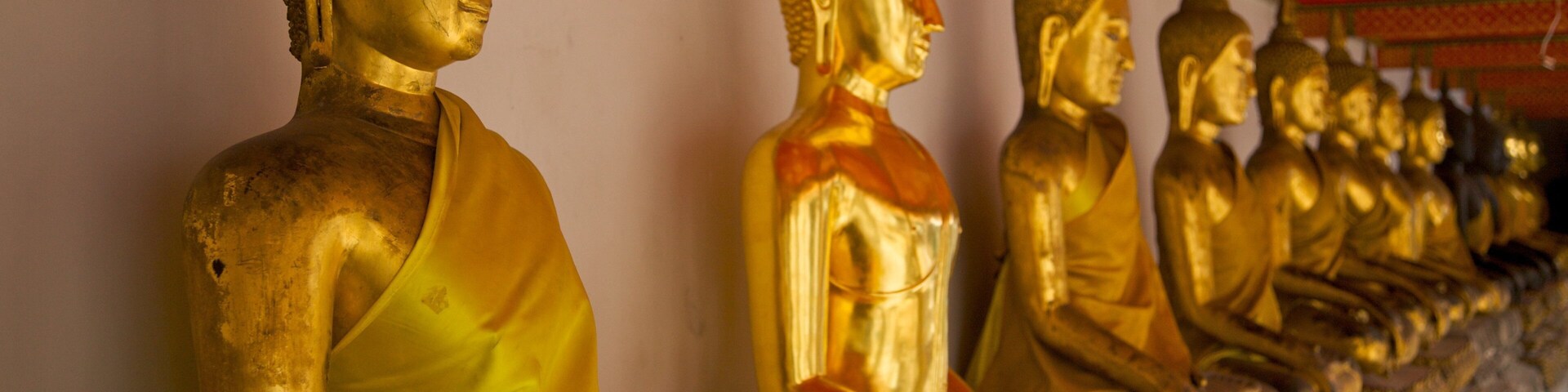 Detailed view of golden Buddha statues at Wat Pho in Bangkok highlighting Thai culture and spirituality