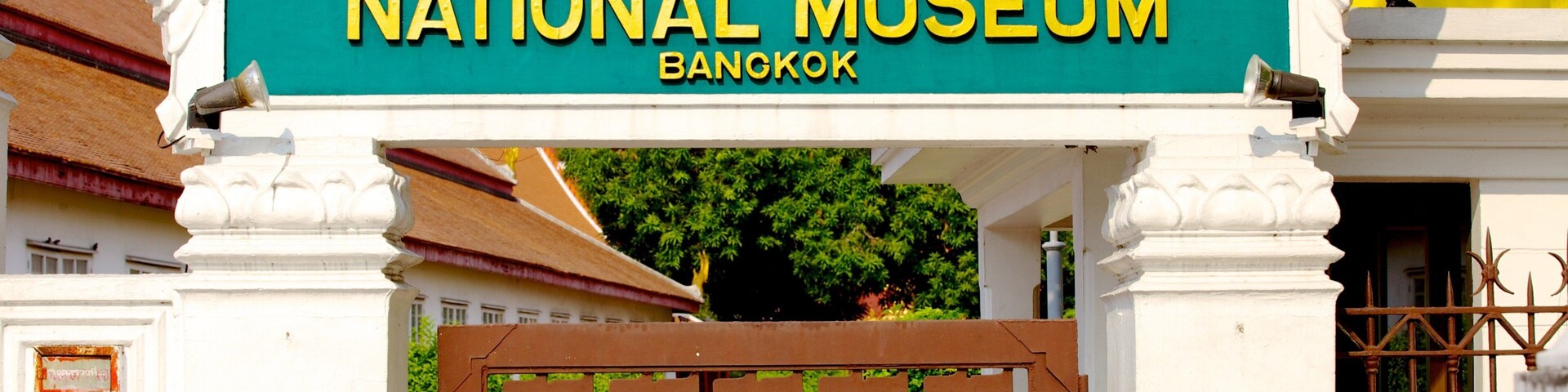 Placa com a inscrição 'National Museum Bangkok' sobre um portão.