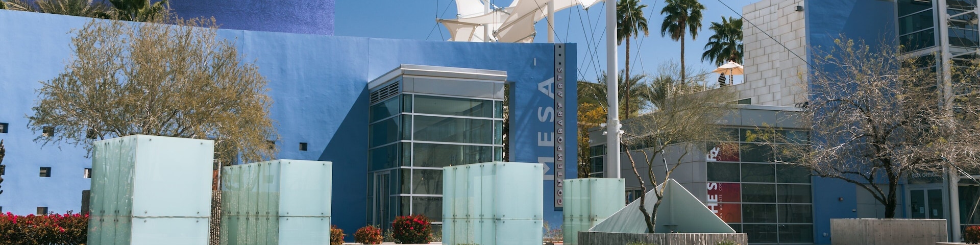Um edifício moderno com fachada azul e estrutura em forma de vela.