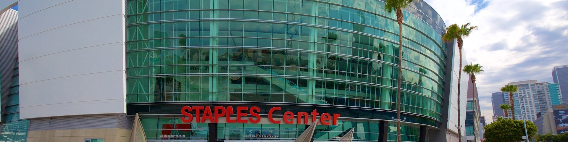 O edifício Staples Center com amplas janelas de vidro e fachada curva.