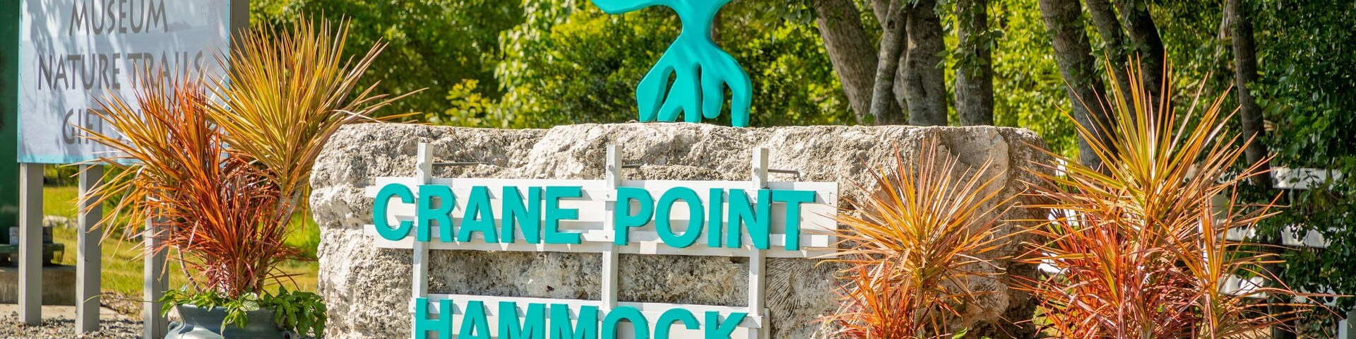 Placa de Crane Point Hammock com o logotipo de uma árvore e plantas em vasos.