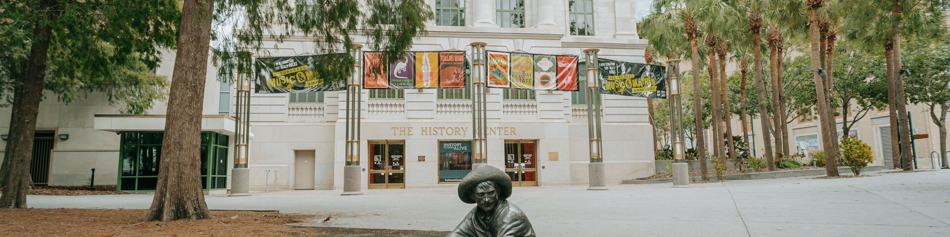 Estátua de um homem com um violão em frente ao The History Center.