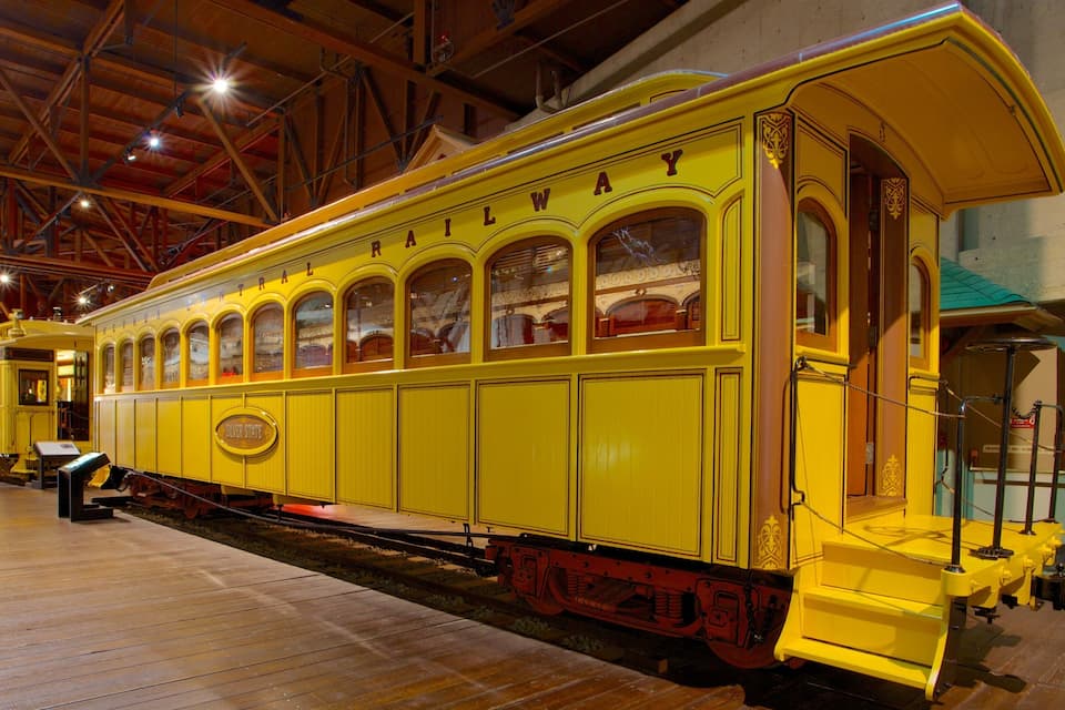 Um antigo vagão de trem amarelo, com a inscrição "Silver State" e "Railway" visível na lateral.