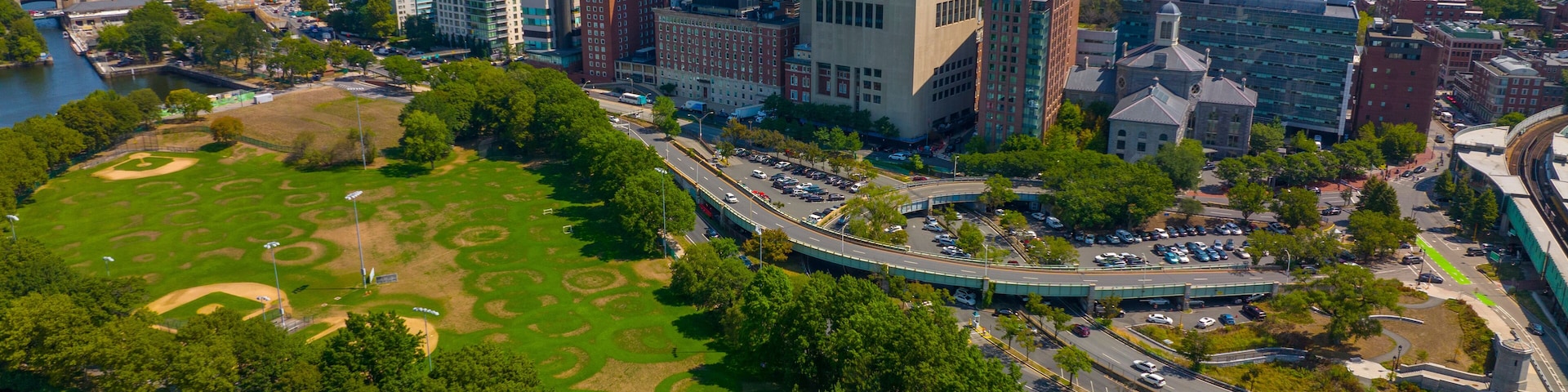 Paisagem urbana com rio, parque verde e edifícios modernos.