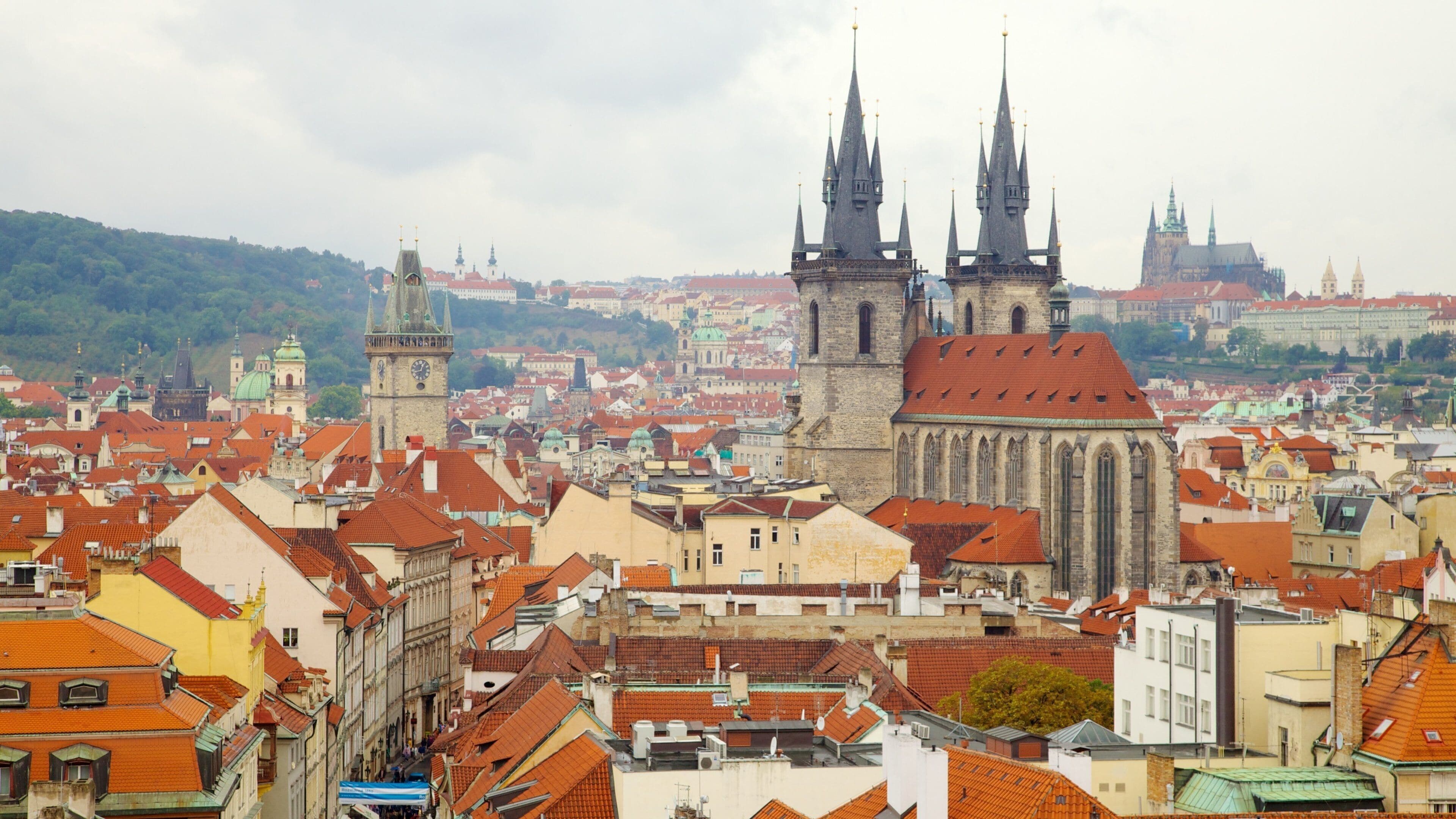 Paisagem urbana com edifícios históricos, uma igreja destacada com duas torres e um campanário.