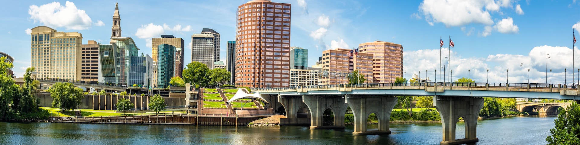Horizonte urbano com edifícios modernos, um rio e uma ponte.