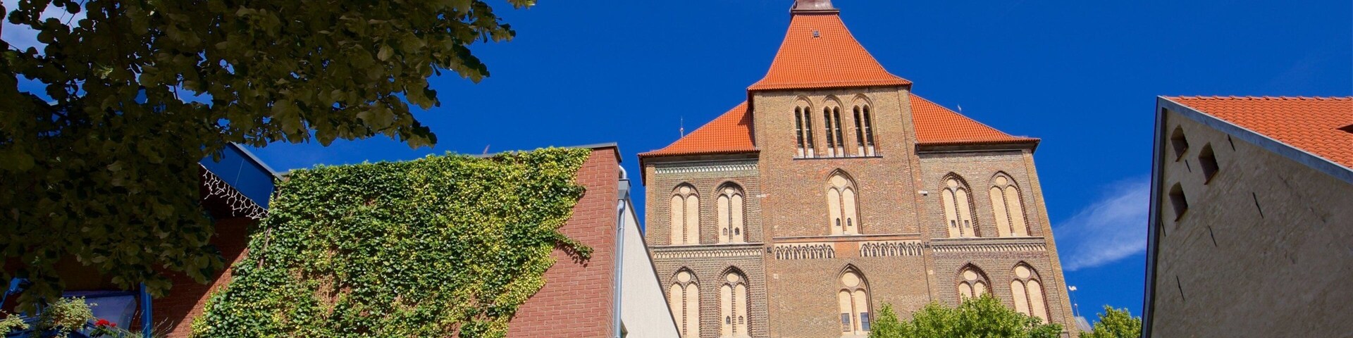 Uma igreja com telhado vermelho e uma torre alta.