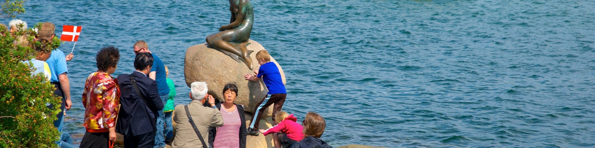 Pequena Sereia caracterizando passeio em veículo, uma estátua ou escultura e paisagens litorâneas