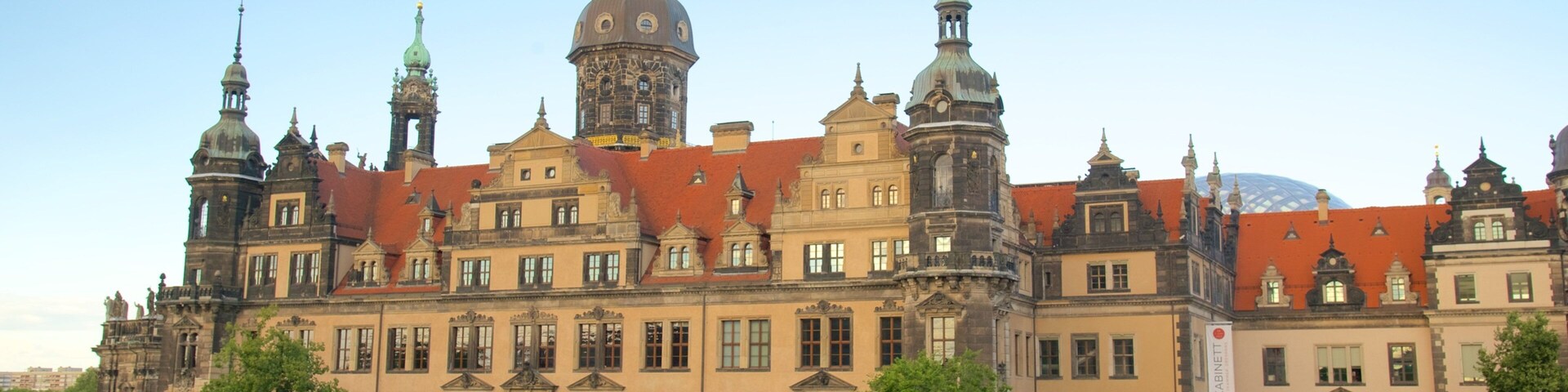 Um edifício histórico com arquitetura ornamentada, incluindo várias torres e uma torre do relógio imponente.