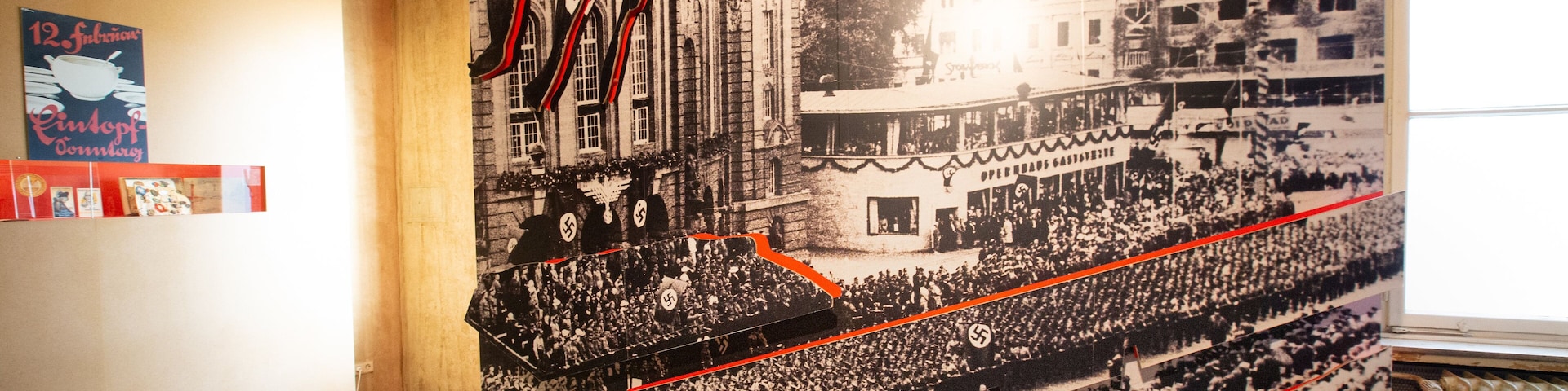 Uma fotografia histórica em grande escala de um evento lotado com uma linha vermelha em destaque.