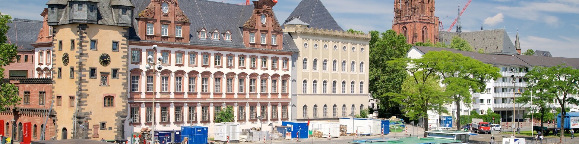 Edifícios históricos com torres e um rio com um barco.