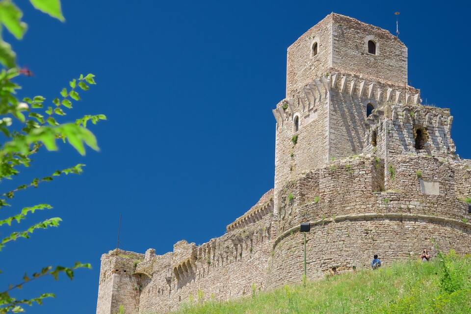 Um castelo de pedra histórico, com uma torre imponente e ameias.