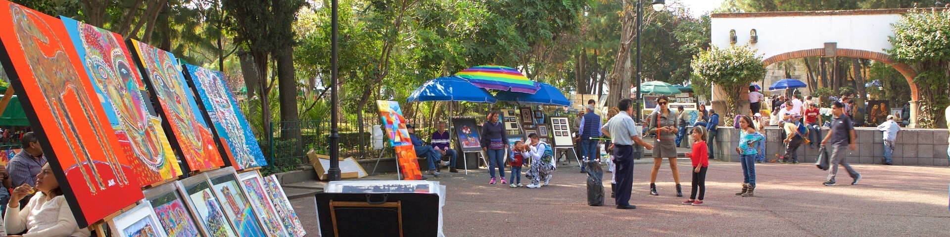 Um mercado de arte ao ar livre vibrante, com pinturas coloridas e uma multidão de pessoas.