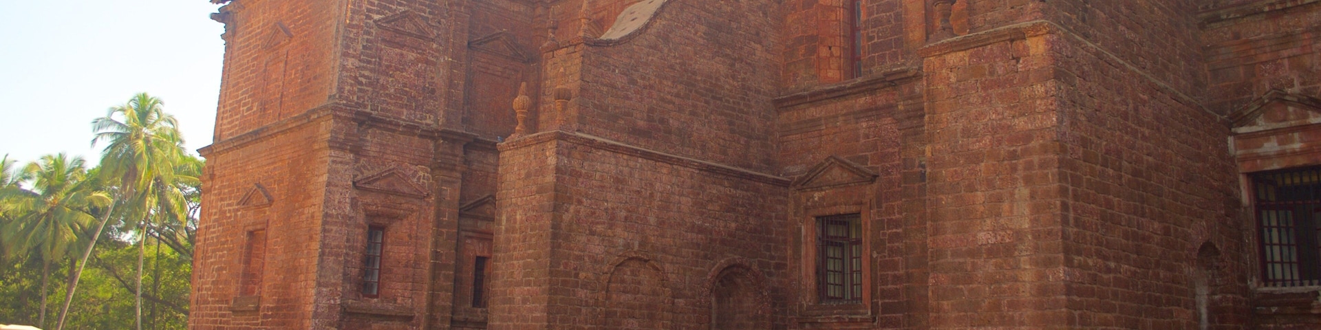 Um grande edifício de tijolos com várias janelas e uma varanda.