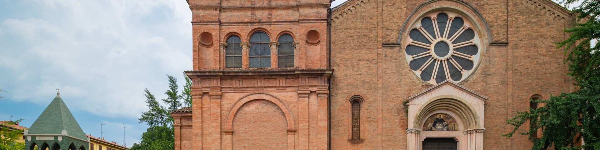 Uma igreja histórica com uma grande janela rosácea e um campanário.