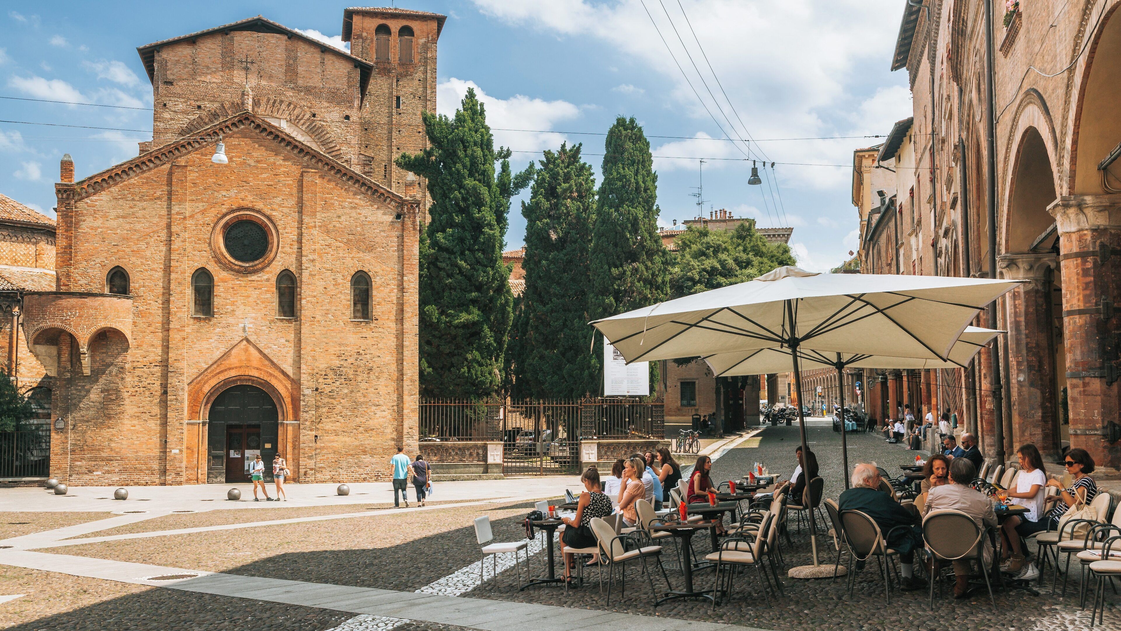 Basilica Santo Stefano welcomes visitors in Bologna, Emilia-Romagna, showcasing historic architecture and vibrant outdoor dining