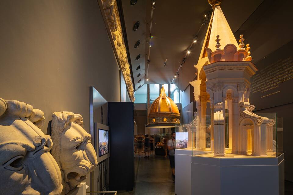 Interior de museu com esculturas clássicas e uma estrutura em cúpula.