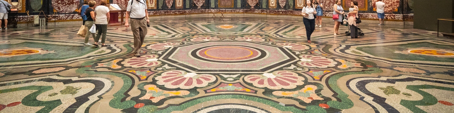 Um salão imponente com um detalhado chão em mosaico e decoração requintada.