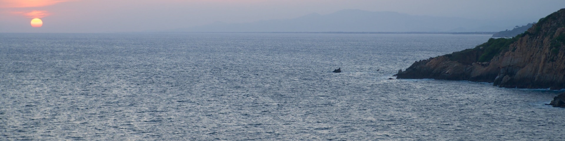 Sinfonia which includes rugged coastline, a sunset and landscape views