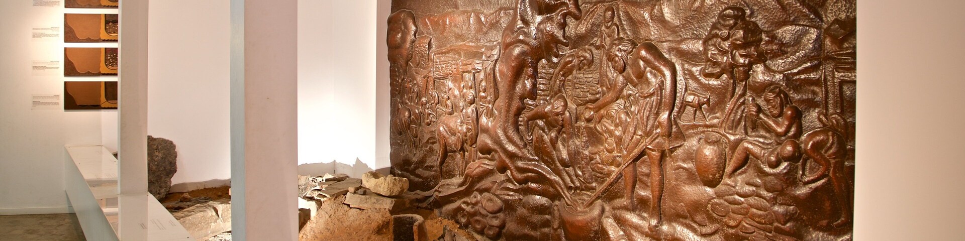 Uma escultura em relevo de bronze detalhada em uma galeria de arte.
