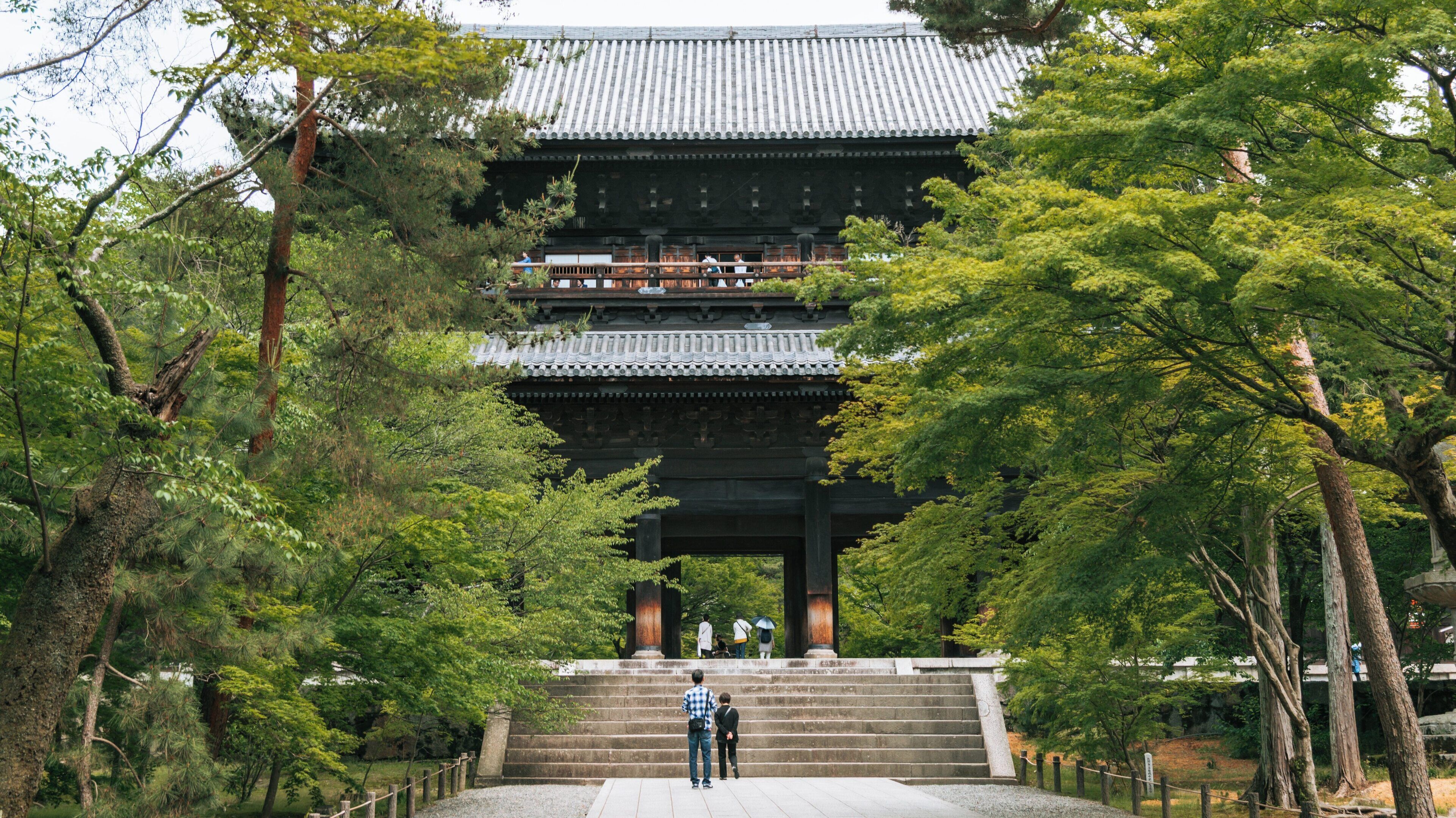 Majestic Nanzen-ji Temple in Higashiyama Ward, Kyoto, surrounded by lush greenery and peaceful visitors enjoying the serene atmosphere
