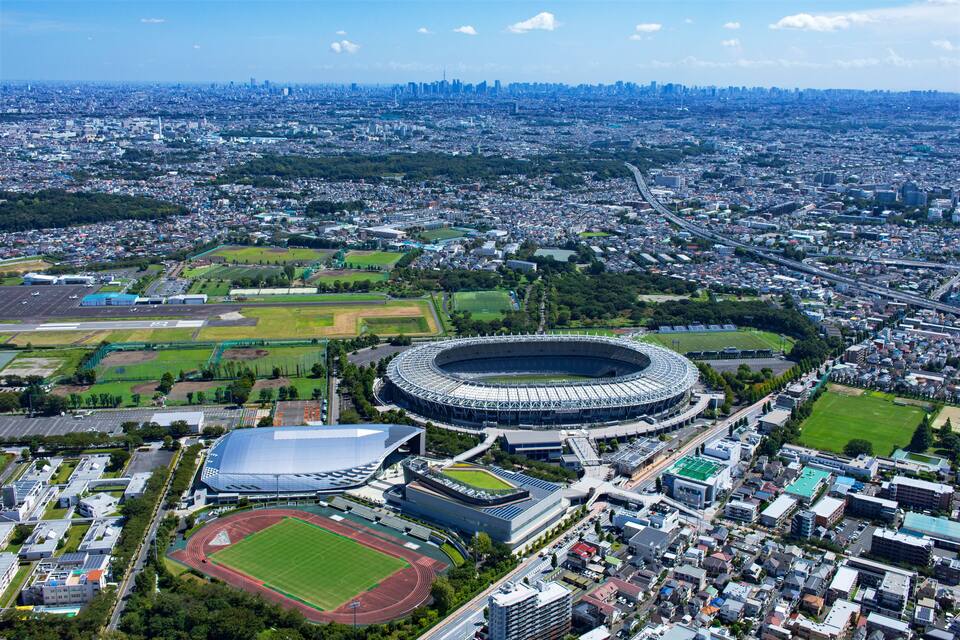 Um grande estádio rodeado por edifícios urbanos e áreas verdes.