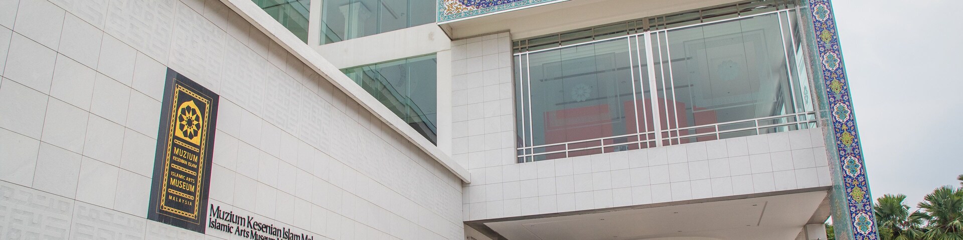 Exterior do Muzium Kesenian, Museu de Arte Islâmica da Malásia, com design moderno e trabalhos em azulejos decorativos.