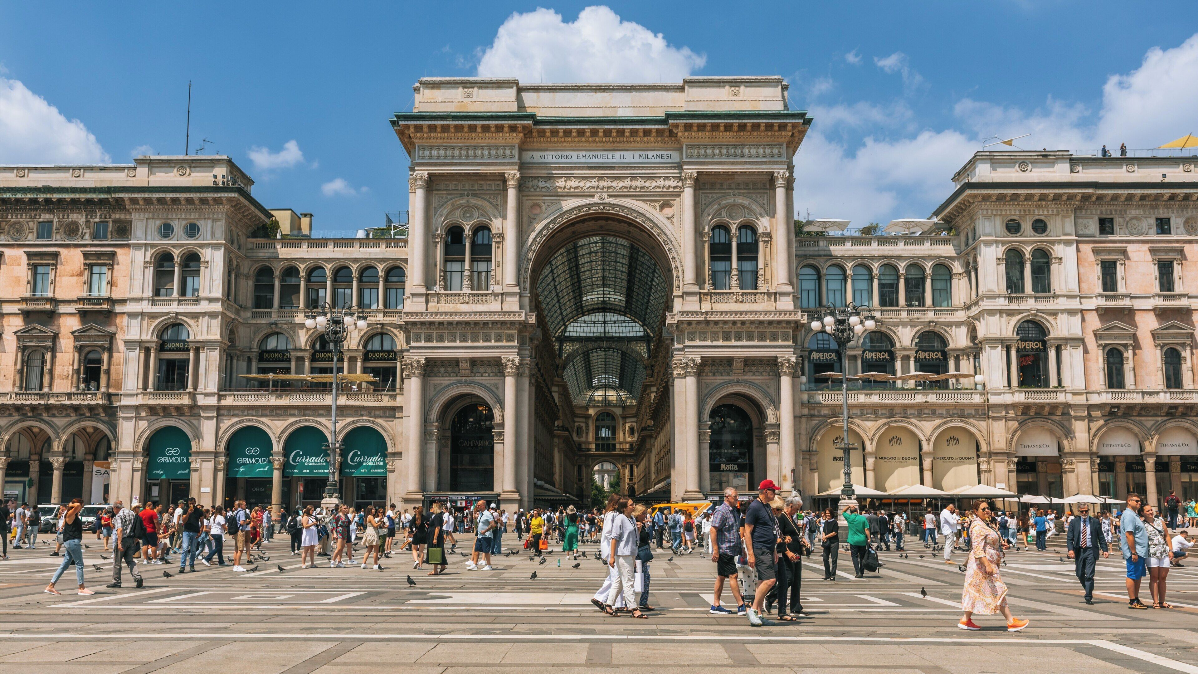 Visitors explore the vibrant Galleria Vittorio Emanuele II in Centro Storico, Milan, Lombardy, Italy on a sunny day