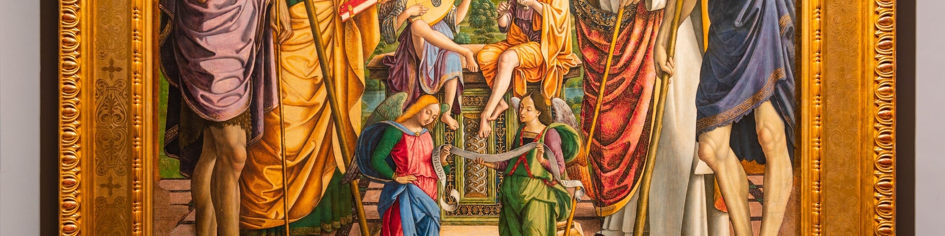 Pintura clássica com figuras vestidas de robes, um cordeiro e um crânio sobre um chão de azulejos.