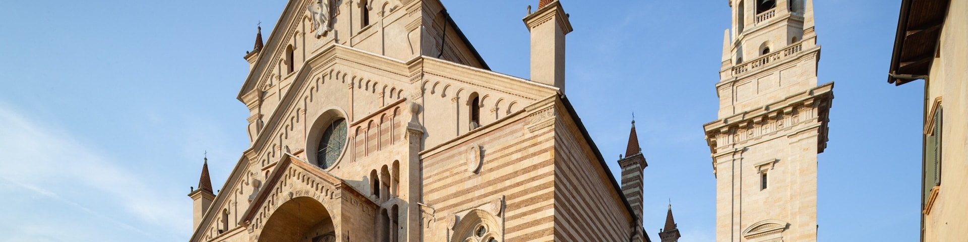 Uma igreja histórica com uma torre de sino imponente e janelas em arco.