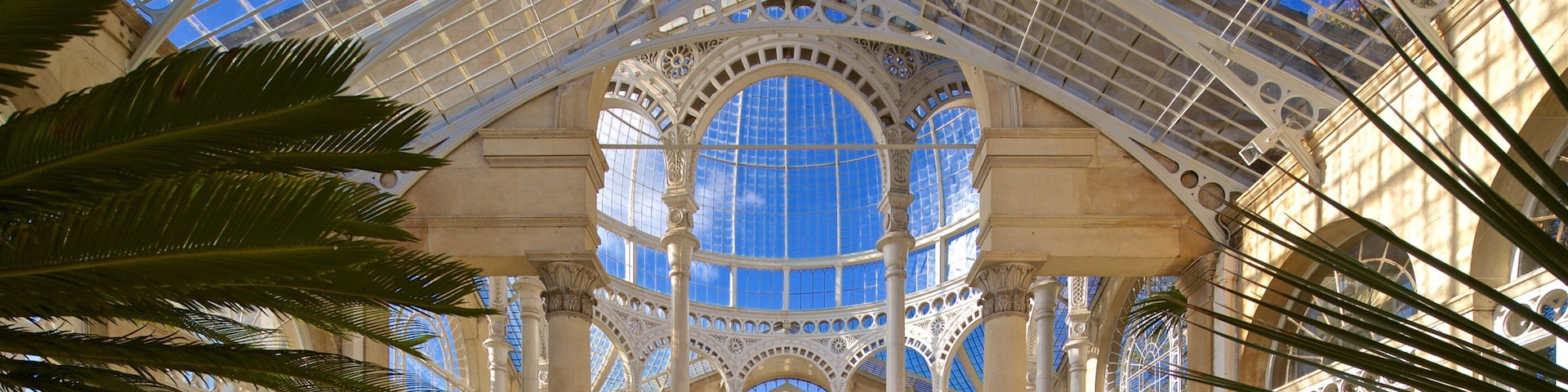 Uma estrutura imponente com cúpula de vidro, colunas e arcos elaborados.