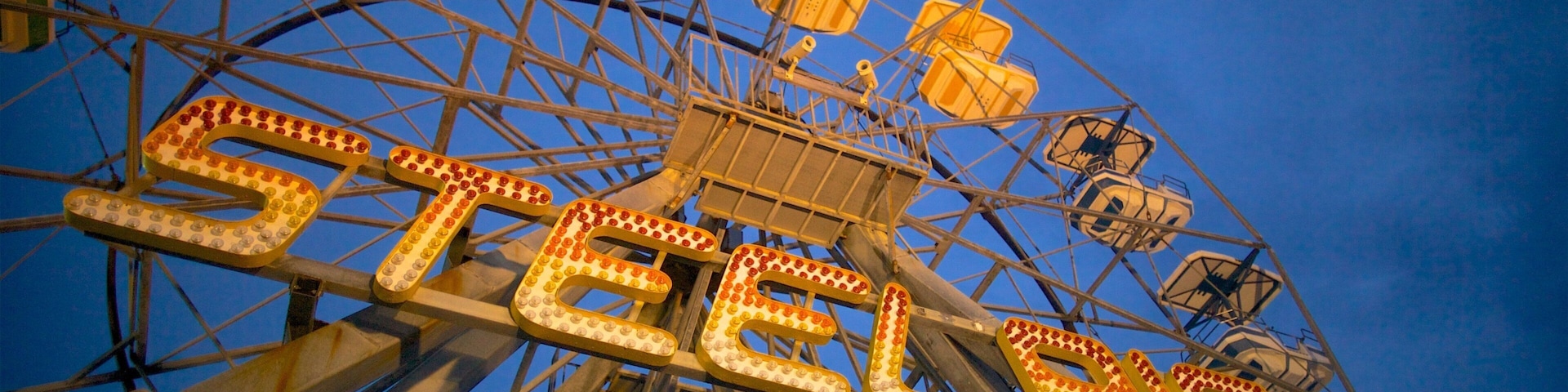 Uma roda gigante com as letras 'STEEL CITY' iluminadas.