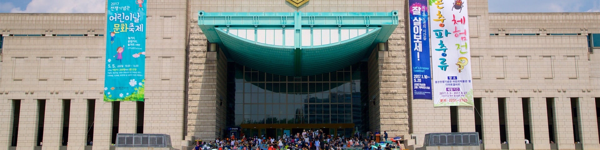 Memorial da Guerra da Coreia do Sul que inclui arquitetura moderna e sinalização assim como um grande grupo de pessoas
