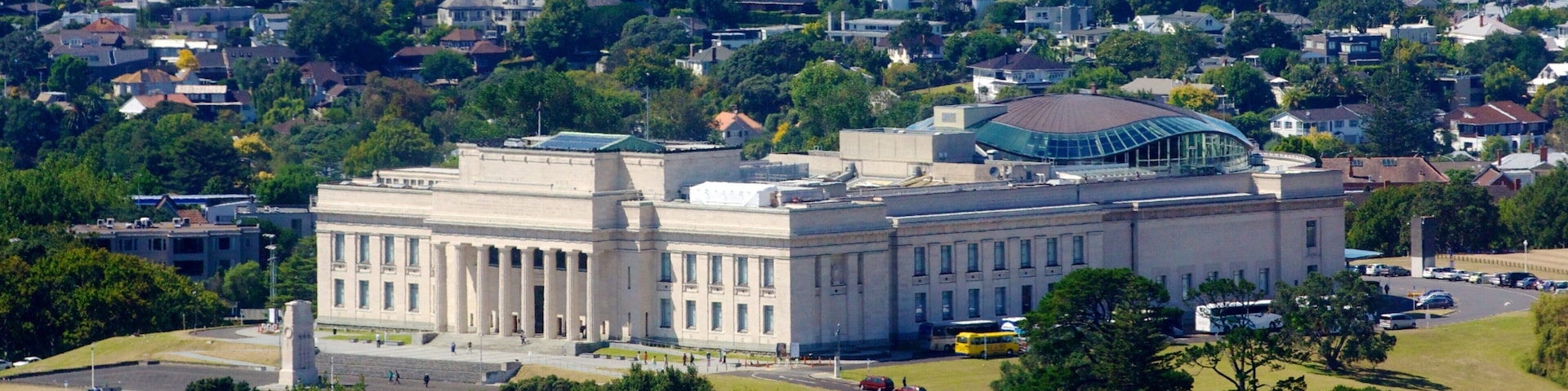 Um grande edifício governamental com cúpula, rodeado por área residencial e vegetação.