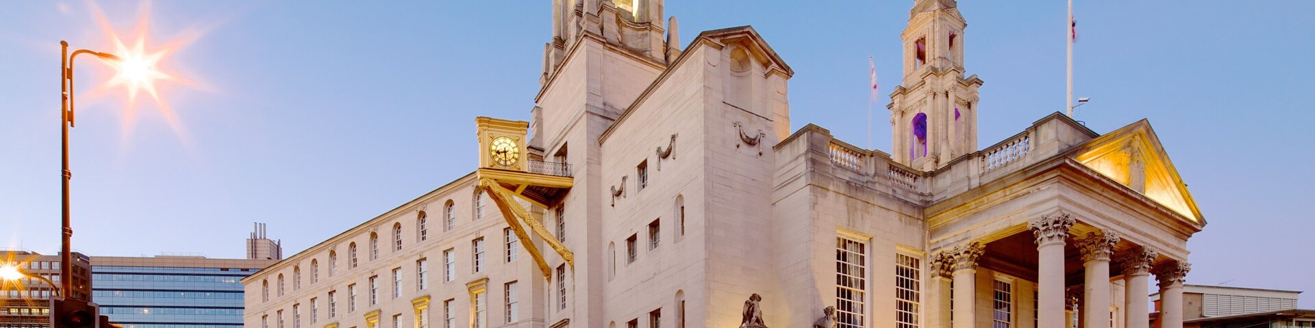 Um edifício histórico com duas torres imponentes e uma estátua em frente.